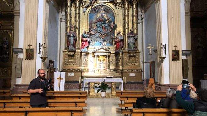 Vecinos y visitantes disfrutan del asoleo en la iglesia de Biscar...